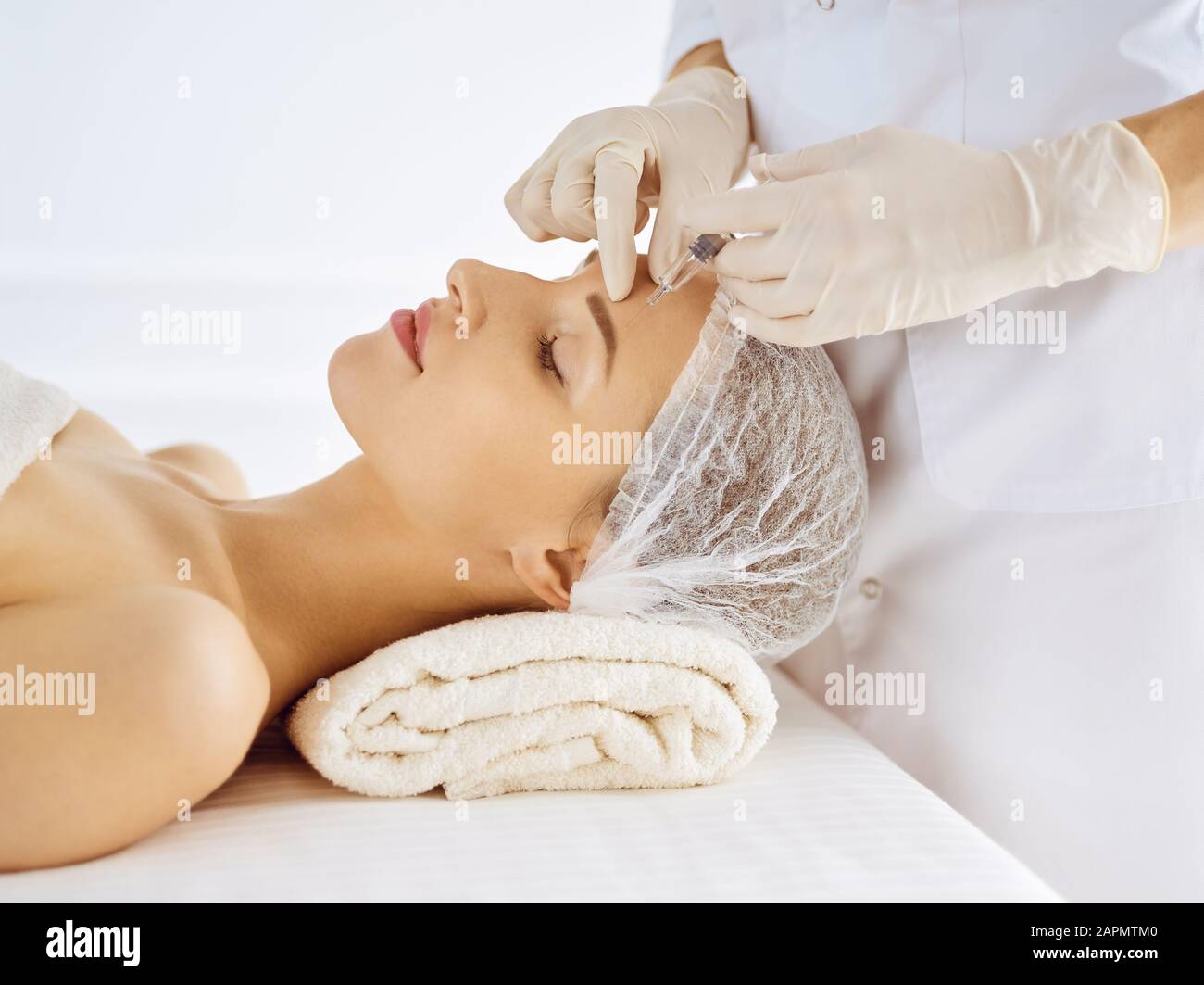 Beautiful woman receiving beauty injections with closed eyes ...