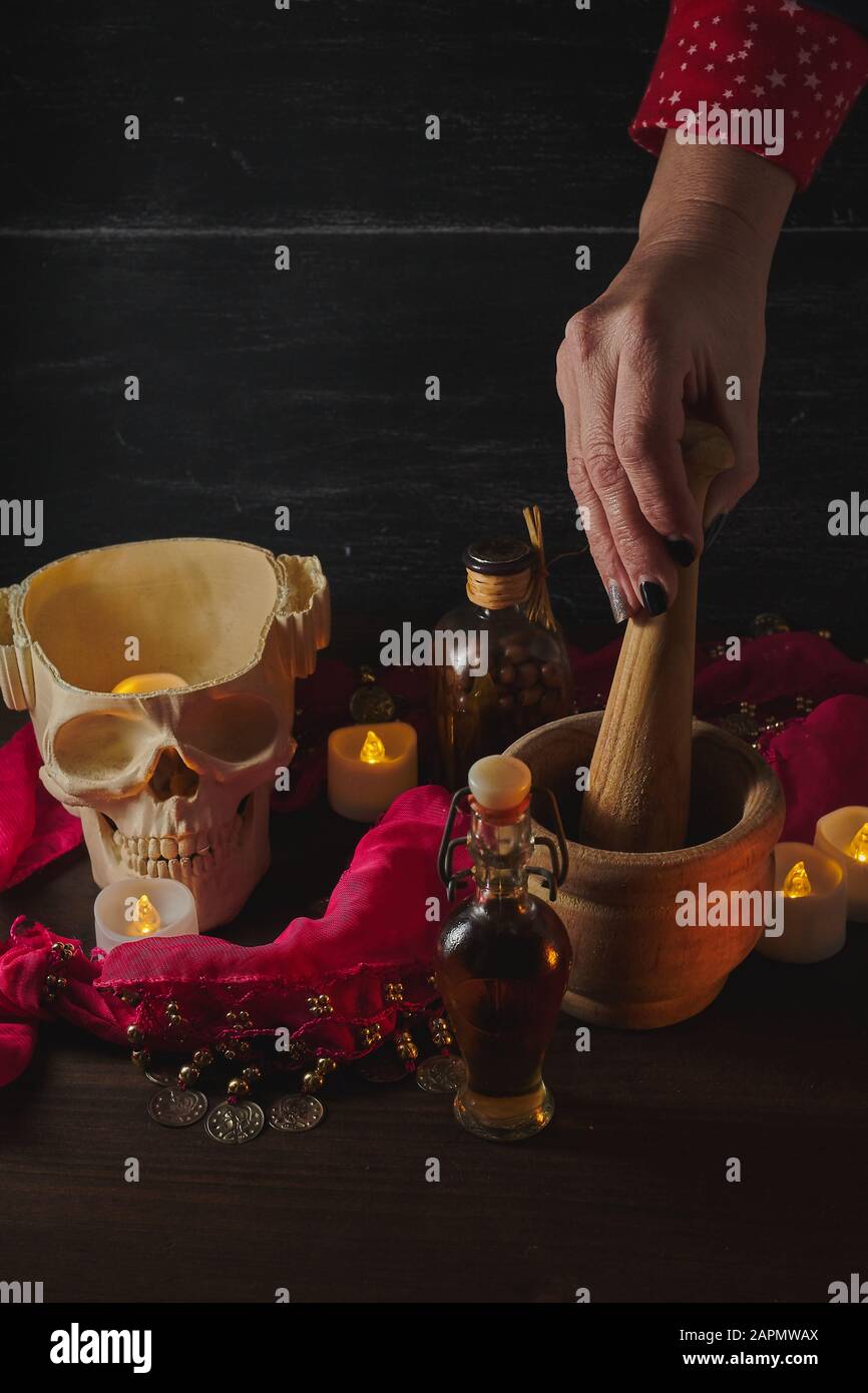 Hand using mortar Scary still life with potions, skull, mortar, vintage ...