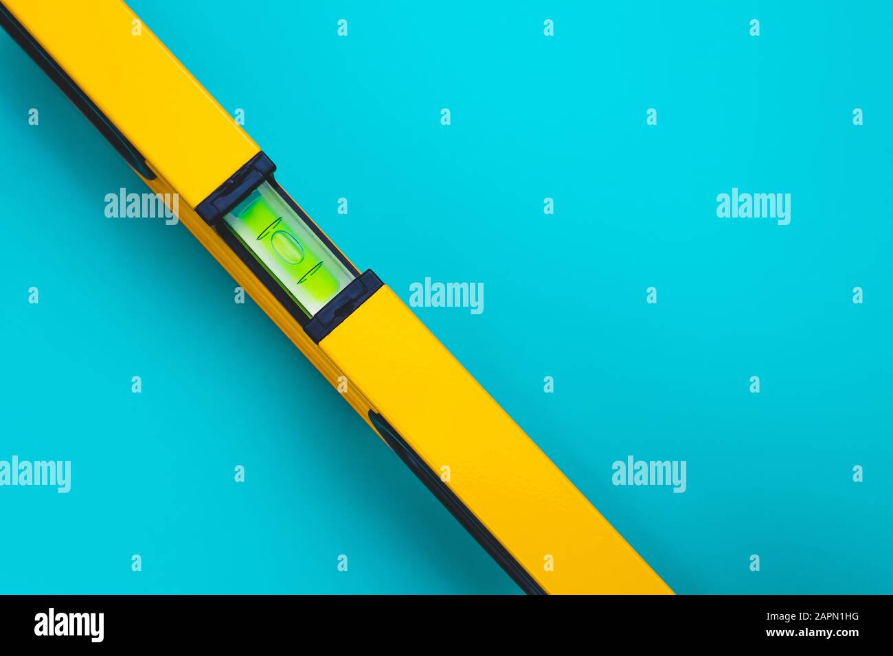 Yellow level tool on blue background. A tubular spirit level. Text ...