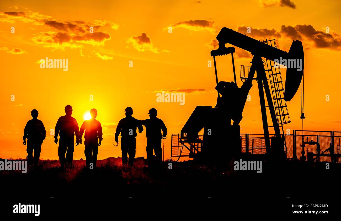 Silhouette of a oilfield worker crude oil pump at sunset Stock Photo ...