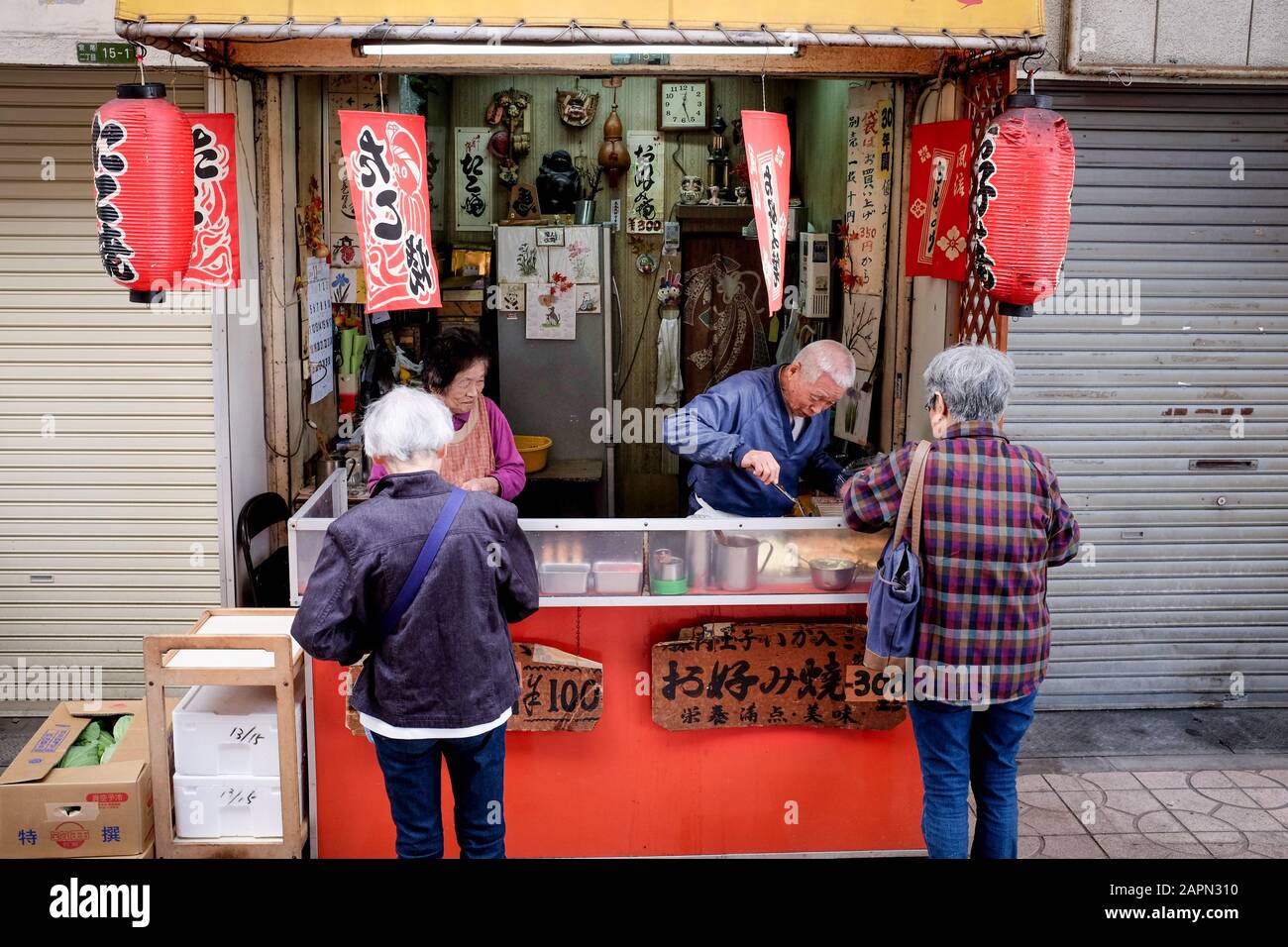 A small food stall run by an elderly couple in Osaka, Japan, that sells ...