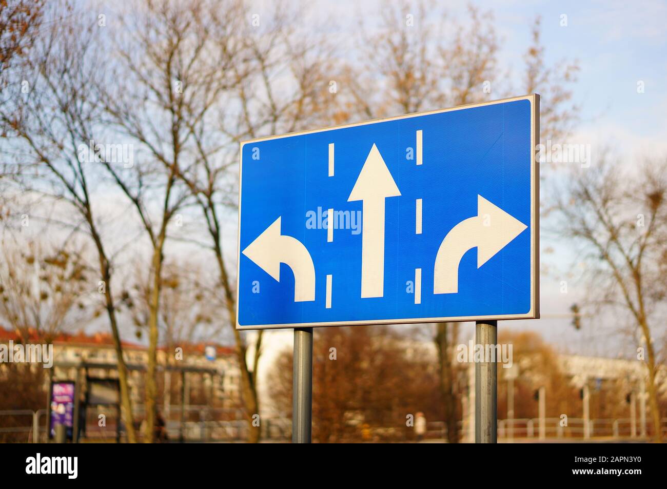 Threeway blue sign on the side of a road at daytime Stock Photo - Alamy