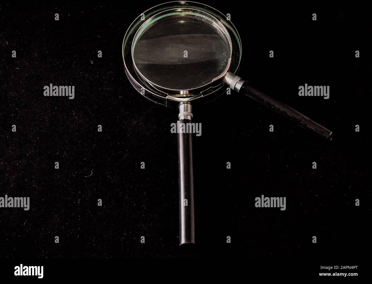 Overhead shot of two different sizes of a magnifying glass with a pitch ...