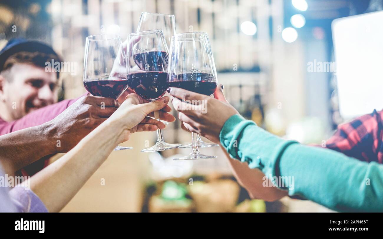 Happy friends cheering with red wine inside trendy winery bar ...