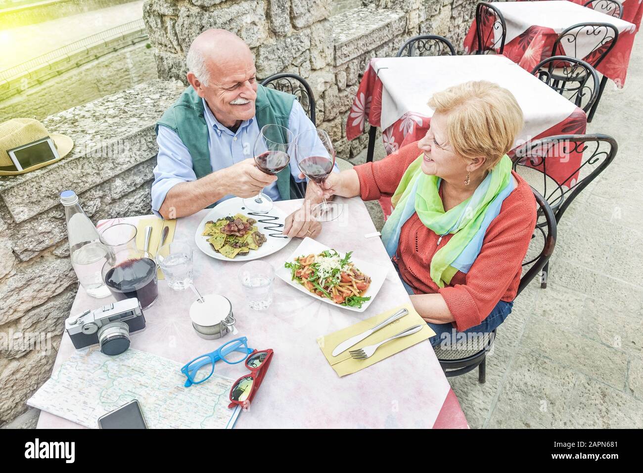 Senior couple toasting wine and eating outdoor - Husband having ...
