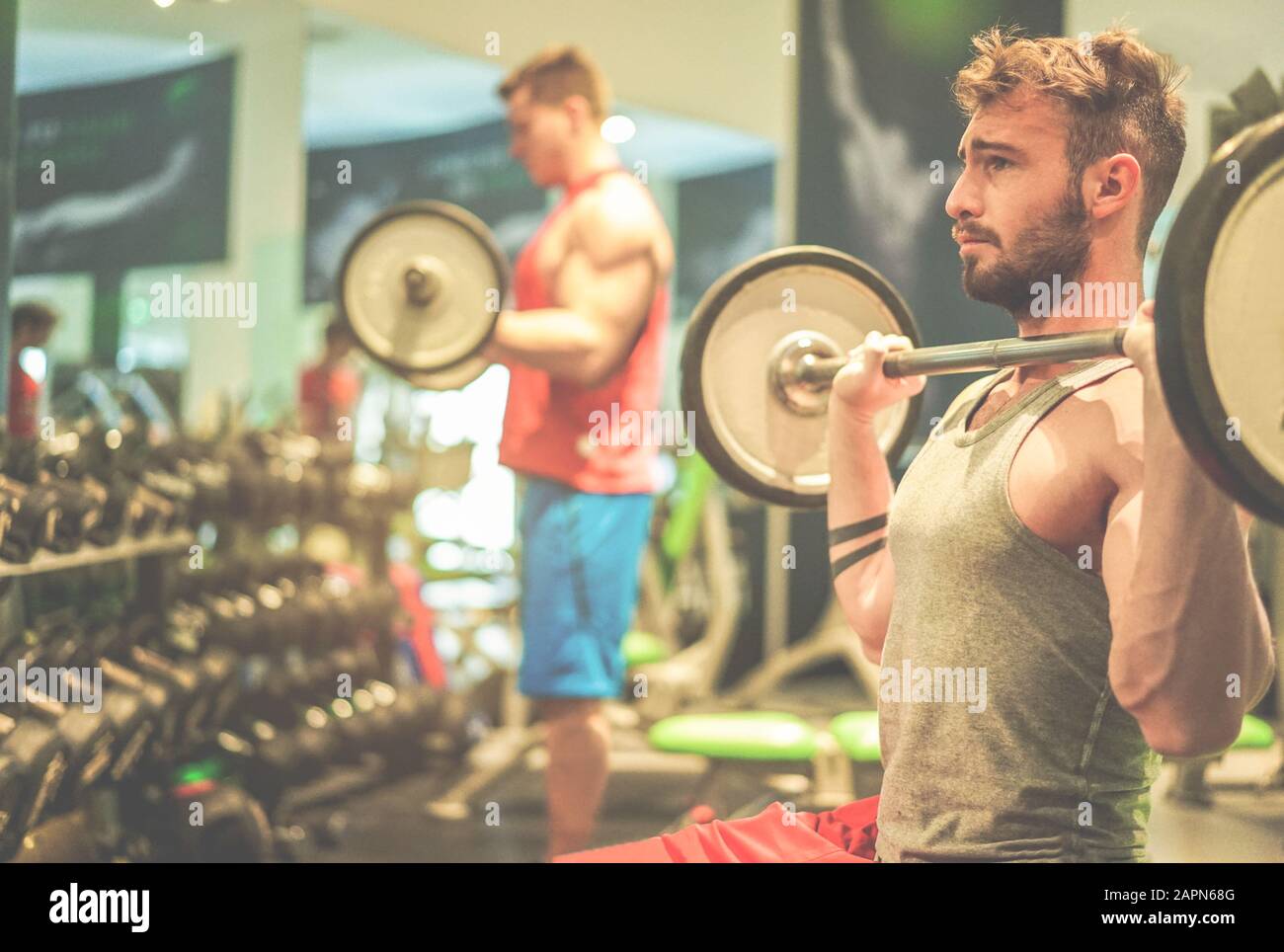 Athletes friends training with barbells inside american gym club ...