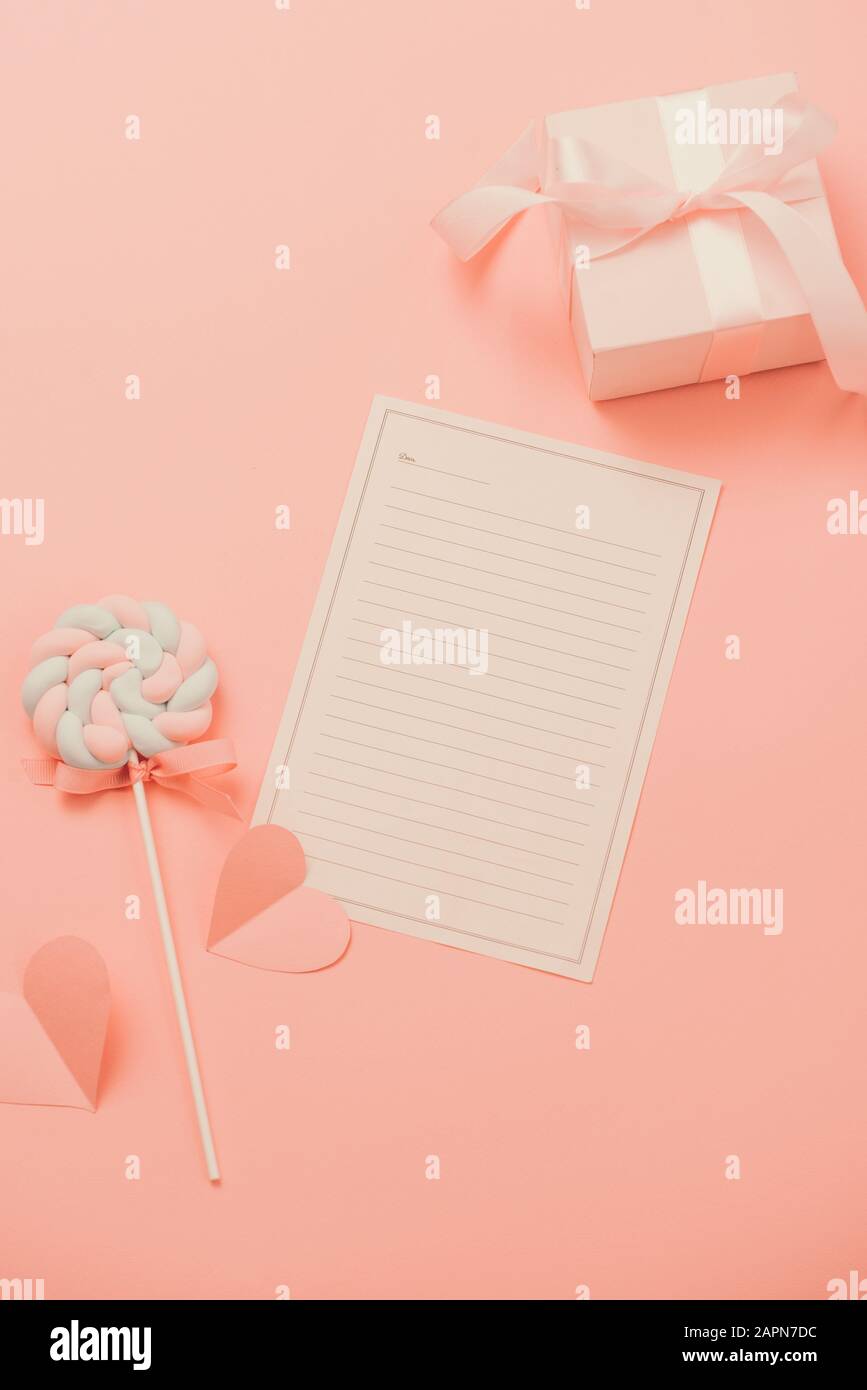 A white sheet of paper for message to loved one, candy on pink ...