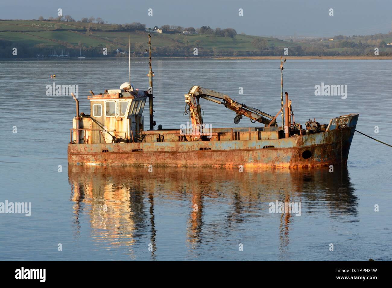 Old rusty rusting fishing boat reflected in the Tywi Estuary Ferryside Carmarthenshire Wales ...