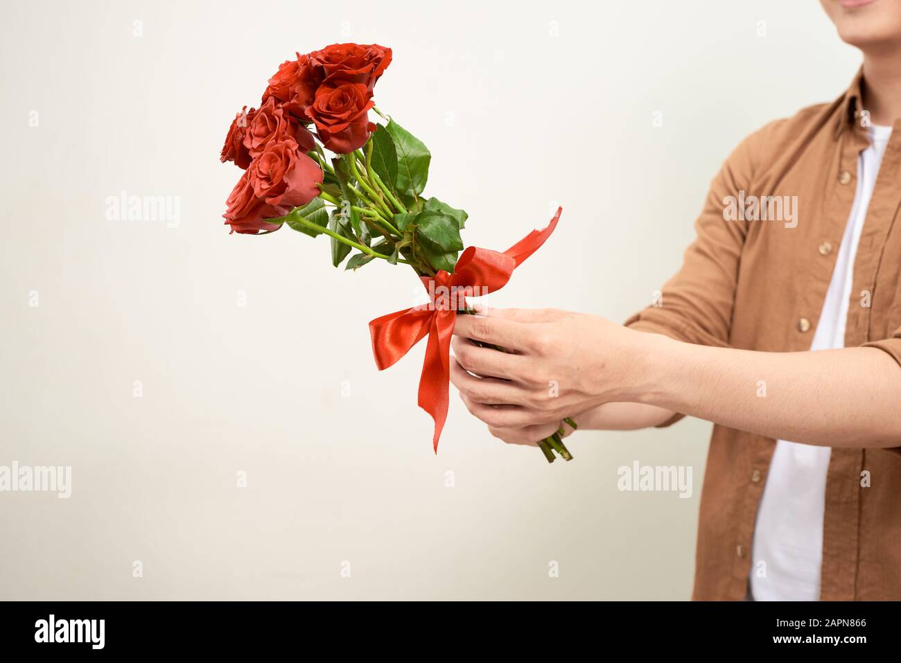 Happy handsome young man holding a bunch of flowers Stock Photo - Alamy