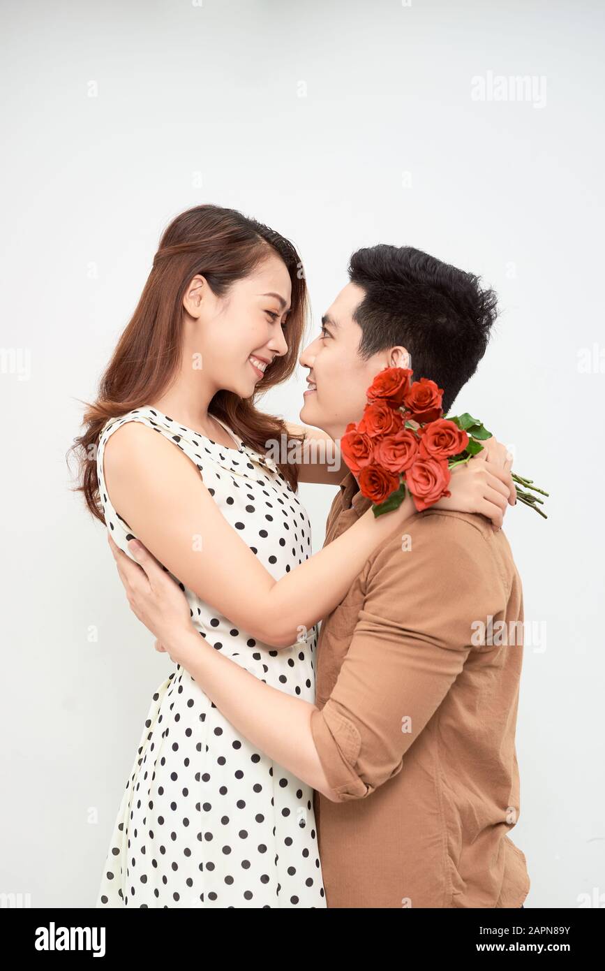 Romantic couple holding red roses against white background Stock Photo ...