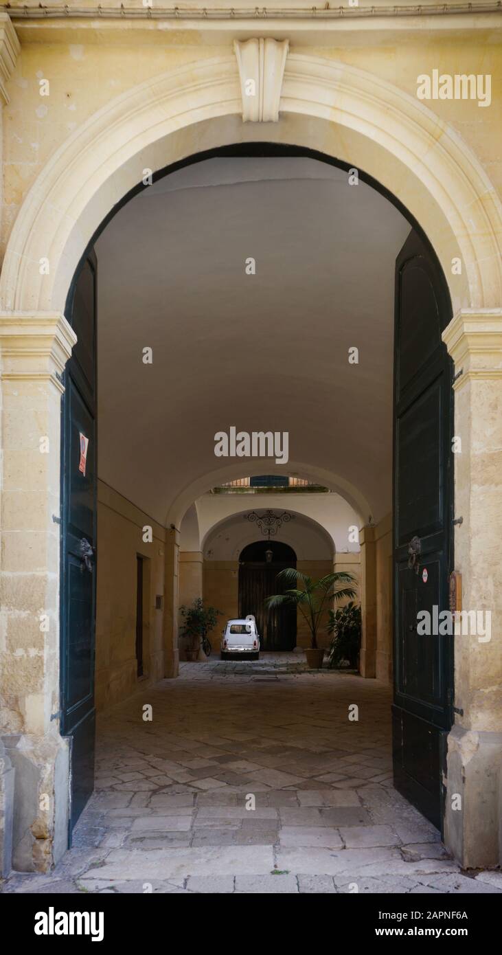 Small Italian Car in a courtyard through an arch Stock Photo - Alamy