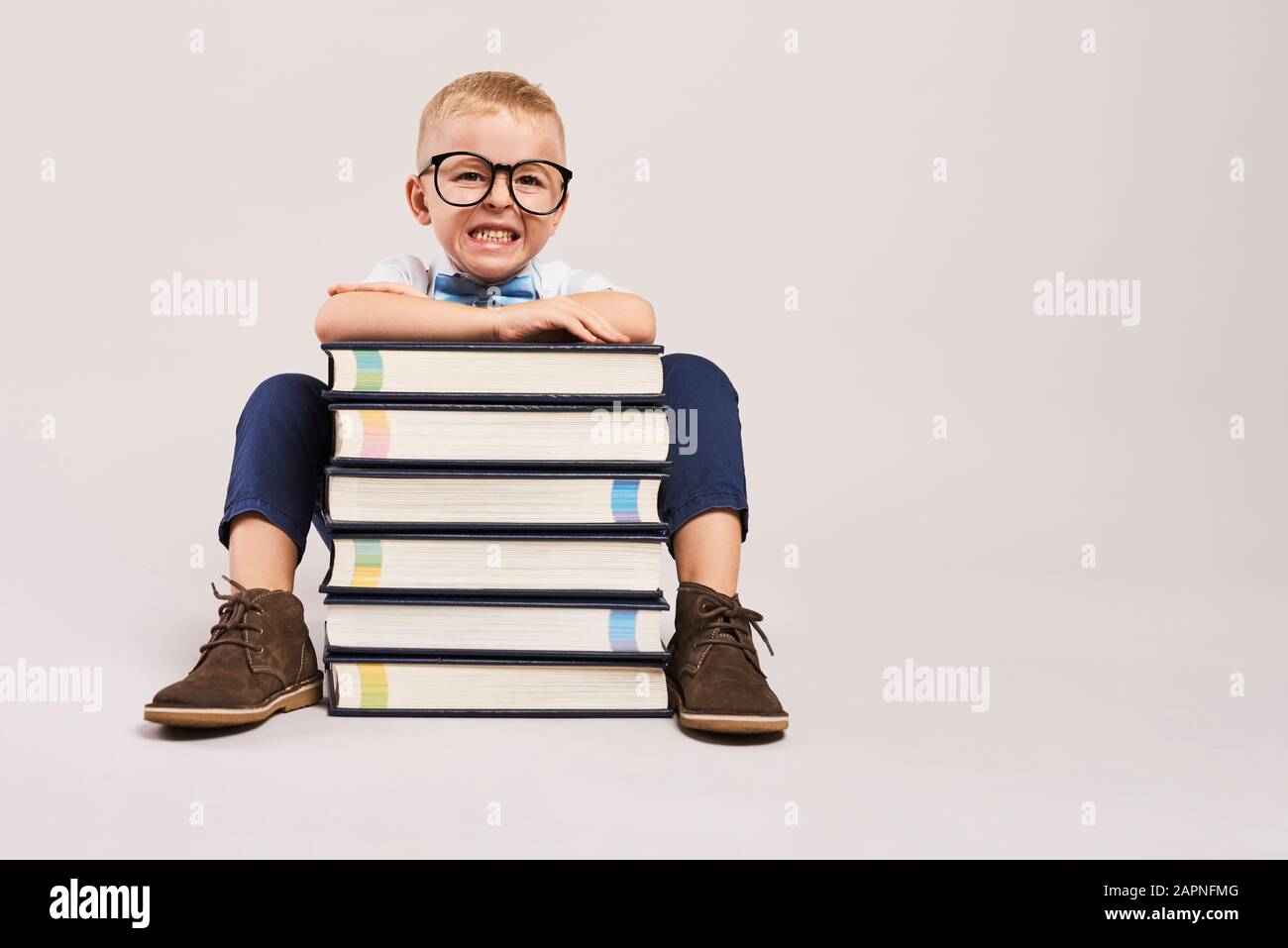 Angry boys with stack of books Stock Photo - Alamy