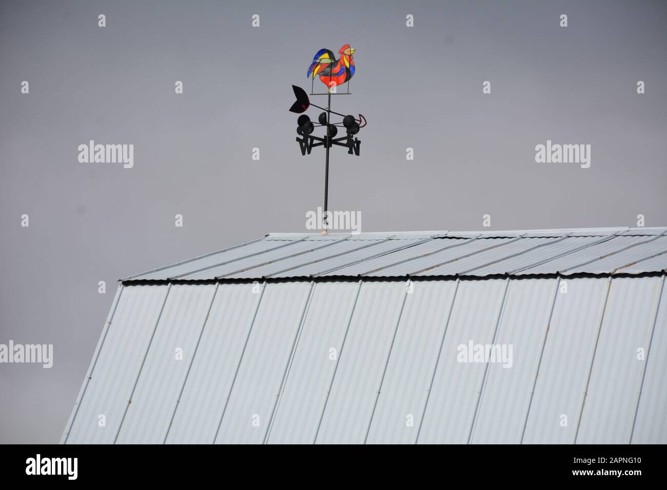 Weathervane on top of steel barn roof Stock Photo - Alamy