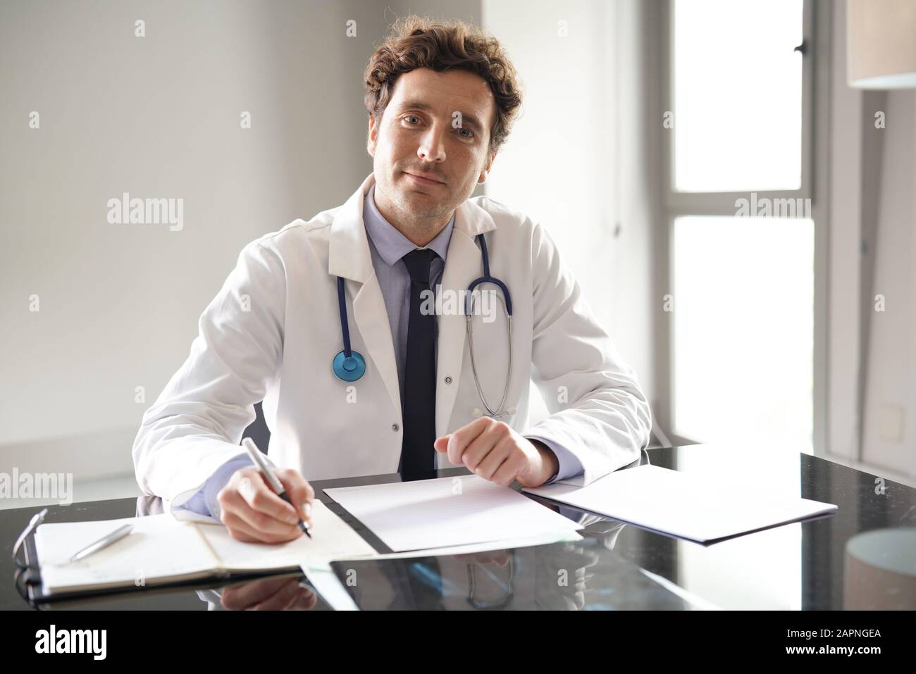 Portrait of doctor writing its conclusions about diagnosis Stock Photo ...
