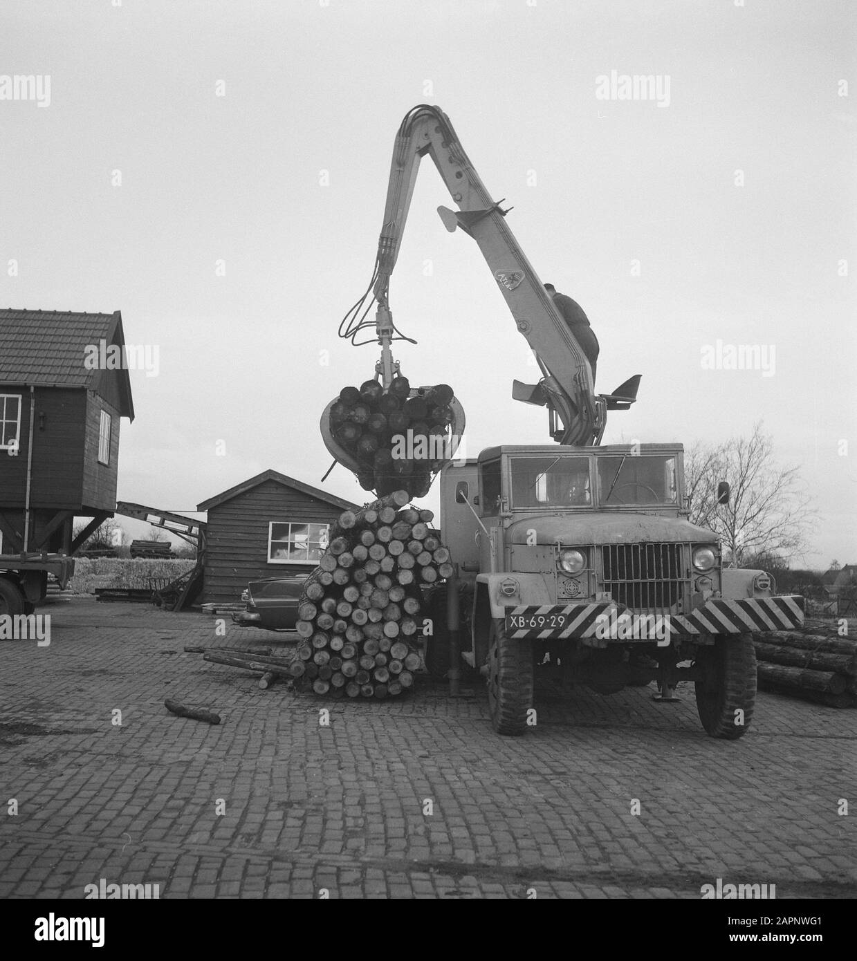 wood storage places, hoist work, workers, tow trucks, logs, buildings ...