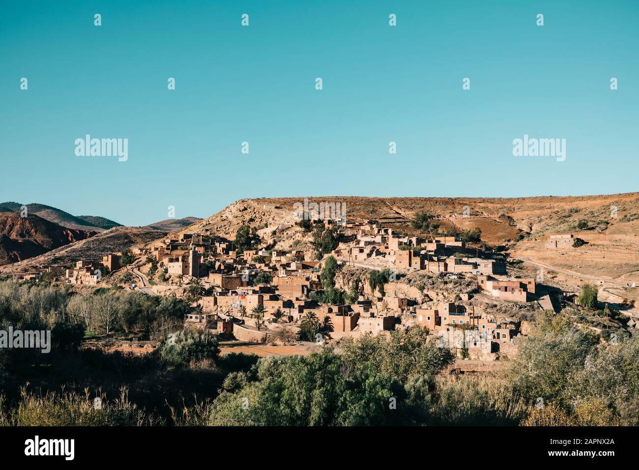 The Berber village of Asni comprised of clay houses built on a hillside ...