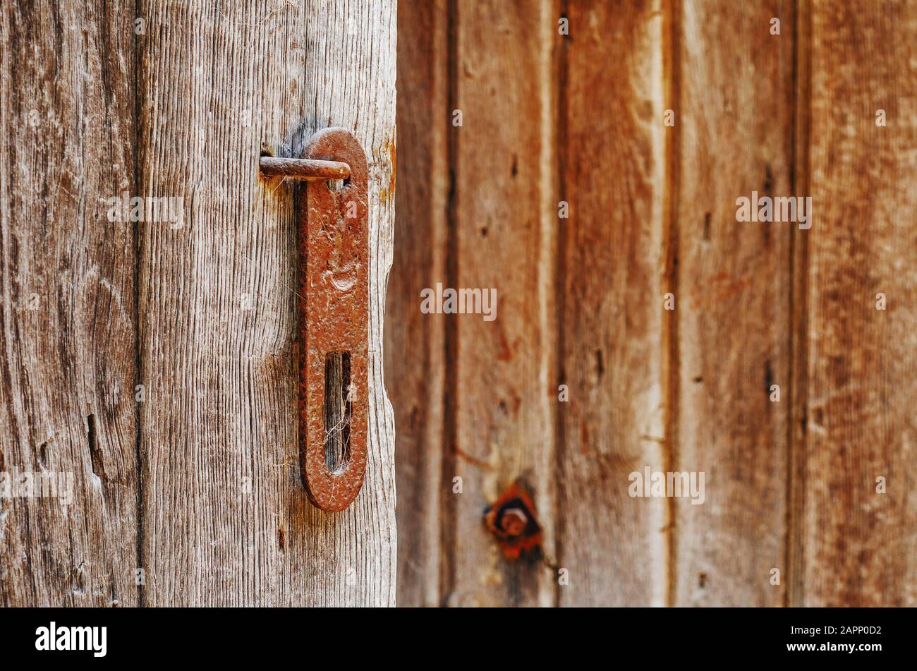 Old rusty deadbolt handle on a weathered wooden door Stock Photo - Alamy