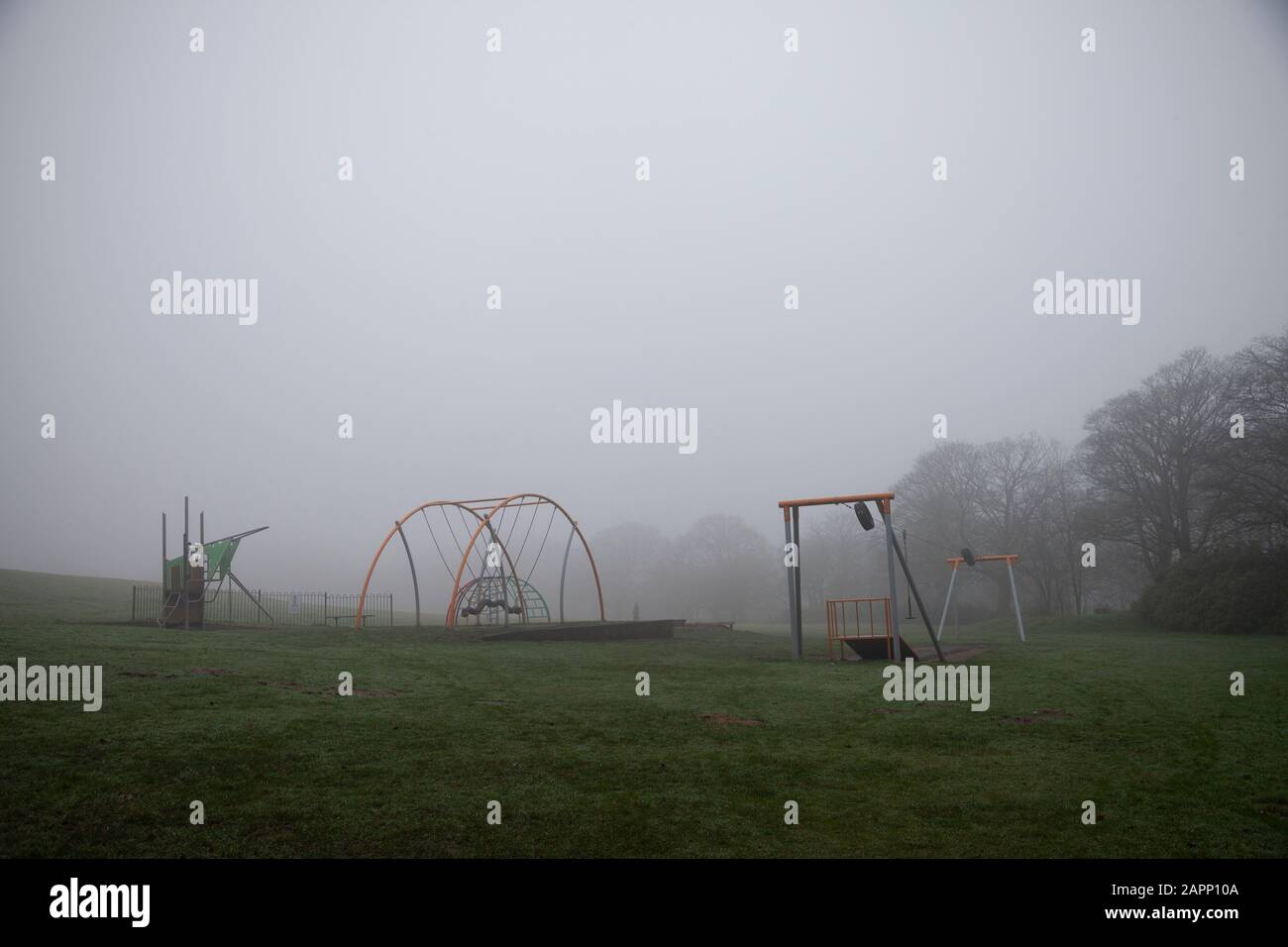 Foggy winter weather covers trees, people, a playground and various ...