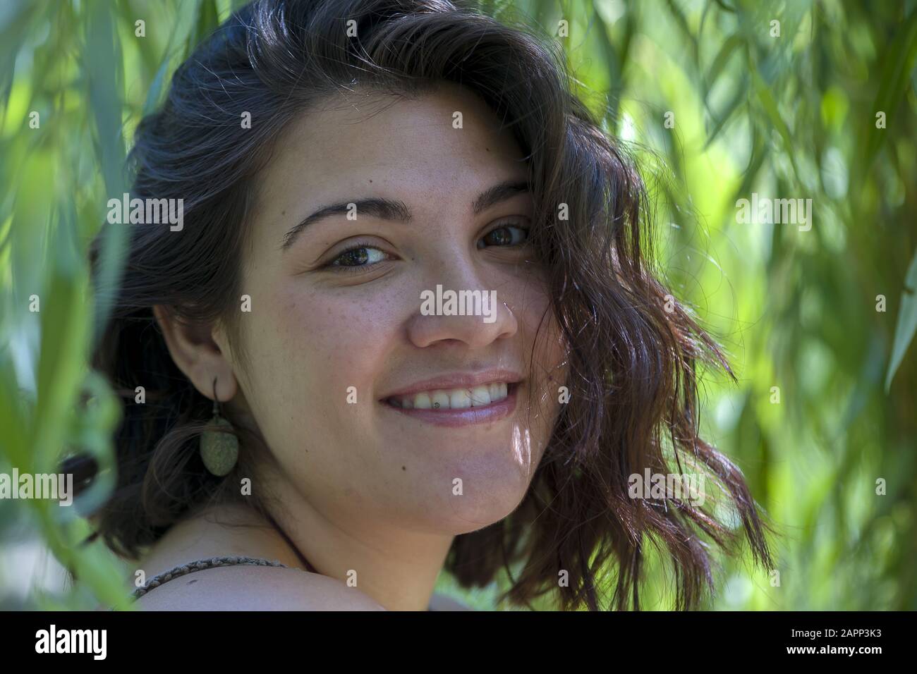 Portrait of a woman under a willow tree with green leaves Stock Photo ...