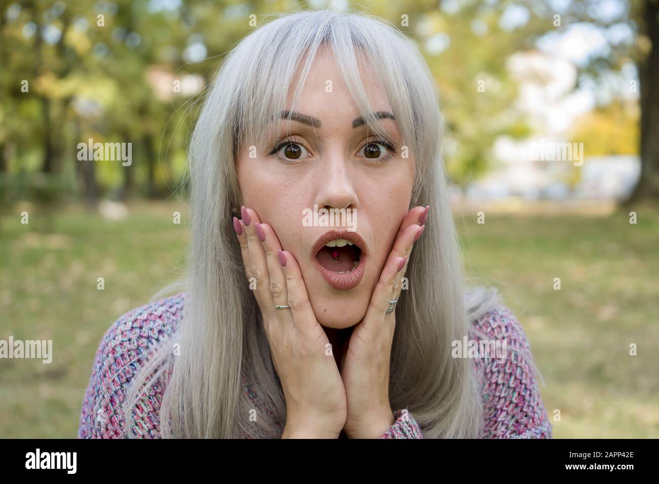 Outdoors portrait of a woman making funny faces. Silver hair Stock ...