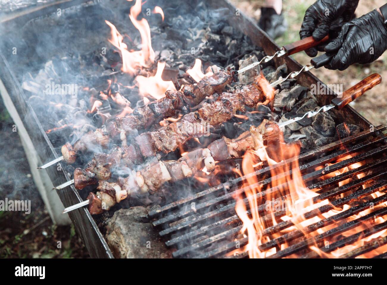 The cook prepares meat-kebab, cut into pieces, barbecue. The meat is ...