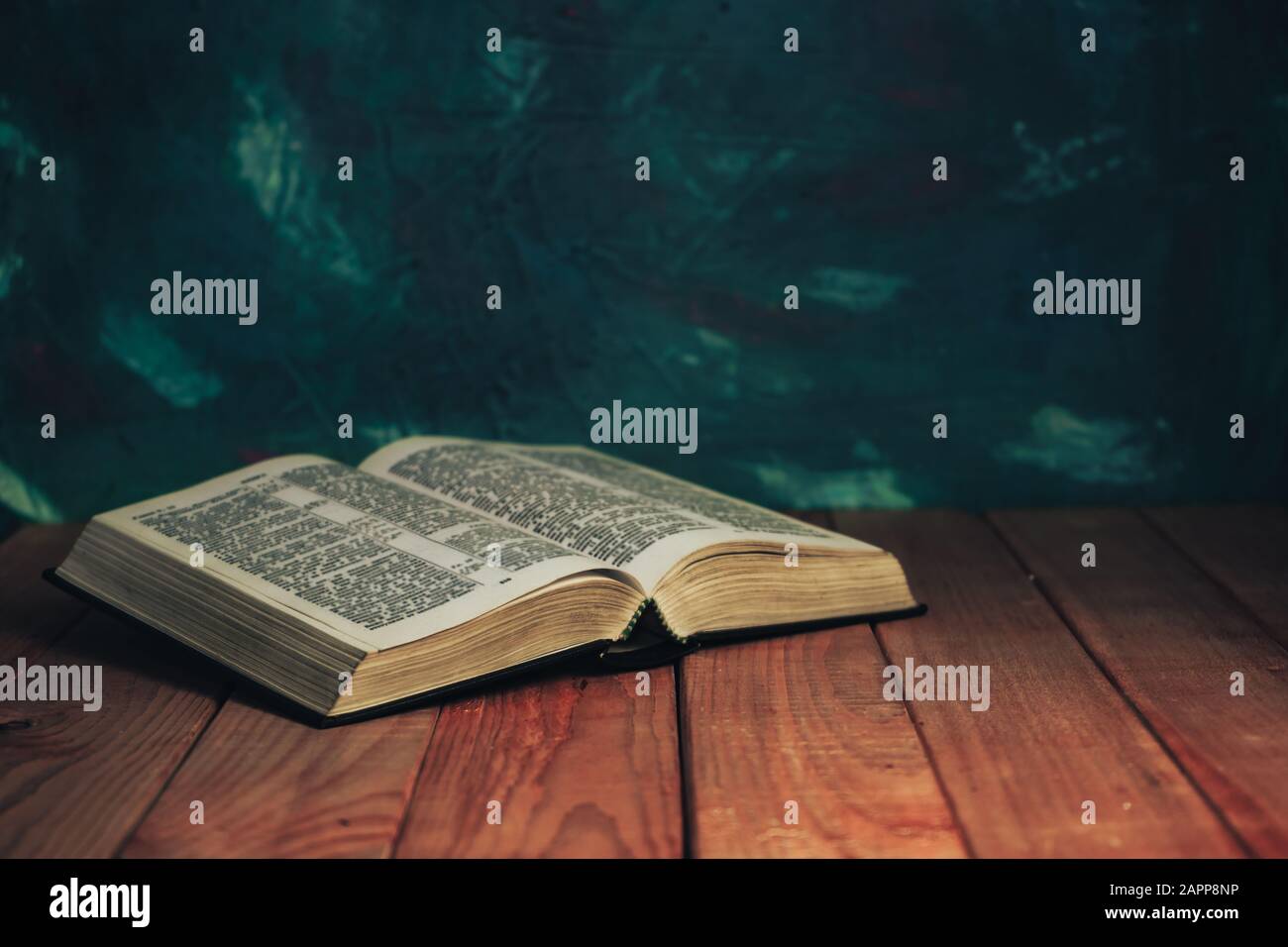 Open bible on a red wooden table. Beautiful green wall background Stock ...