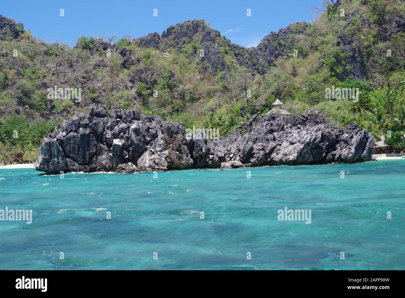 A big, jagged rock jutting out of the sea just of the coast of one of ...