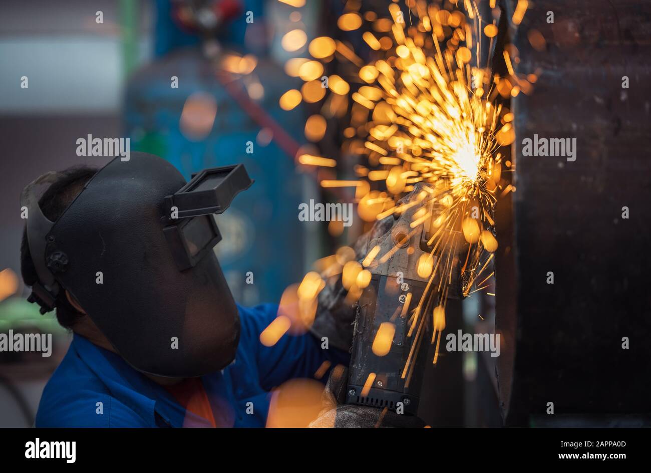 Electric wheel grinding on steel structure in factory Stock Photo - Alamy