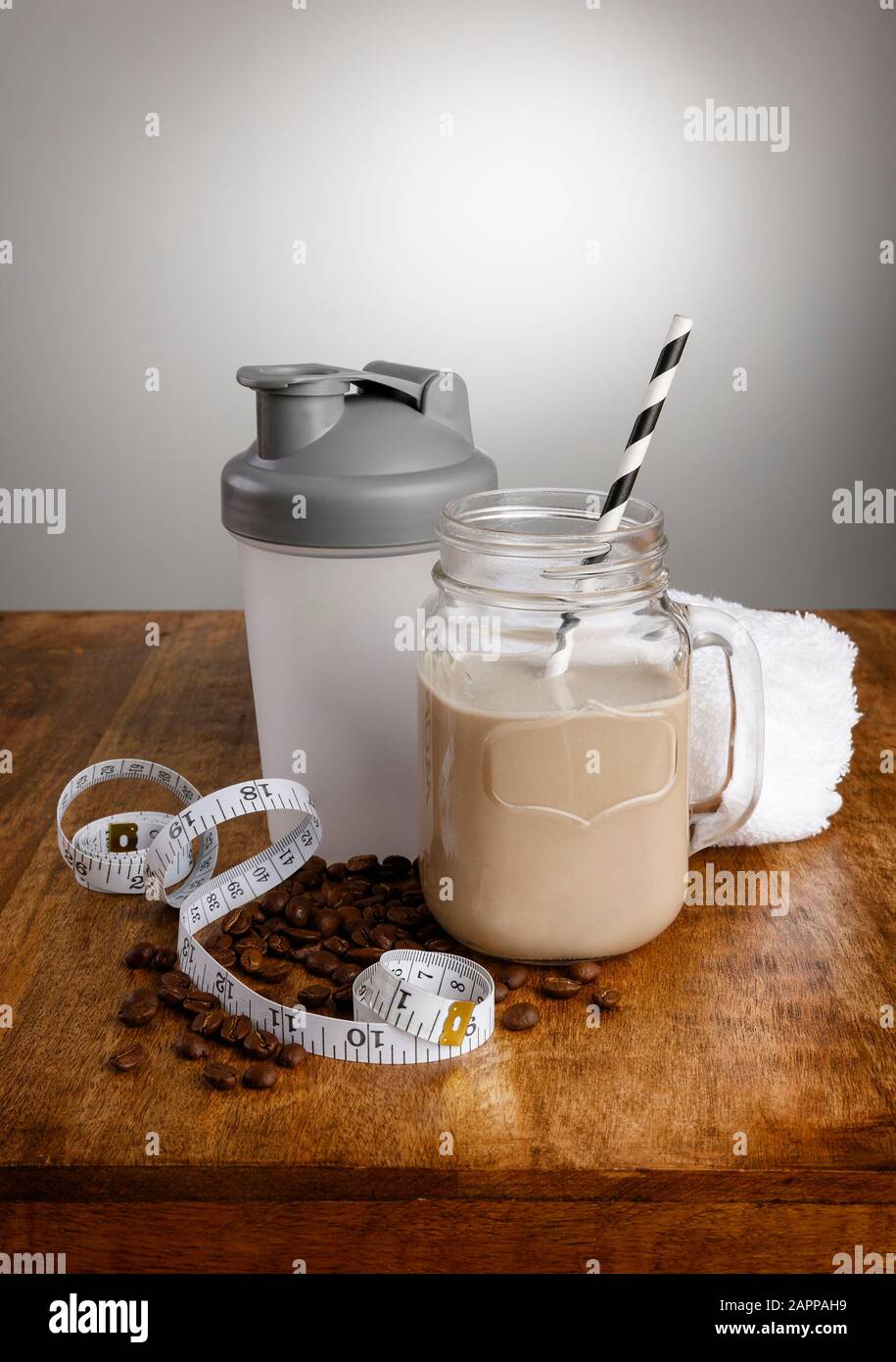 Coffee milkshake, ingredients, tape measure and shaker with paper straw ...