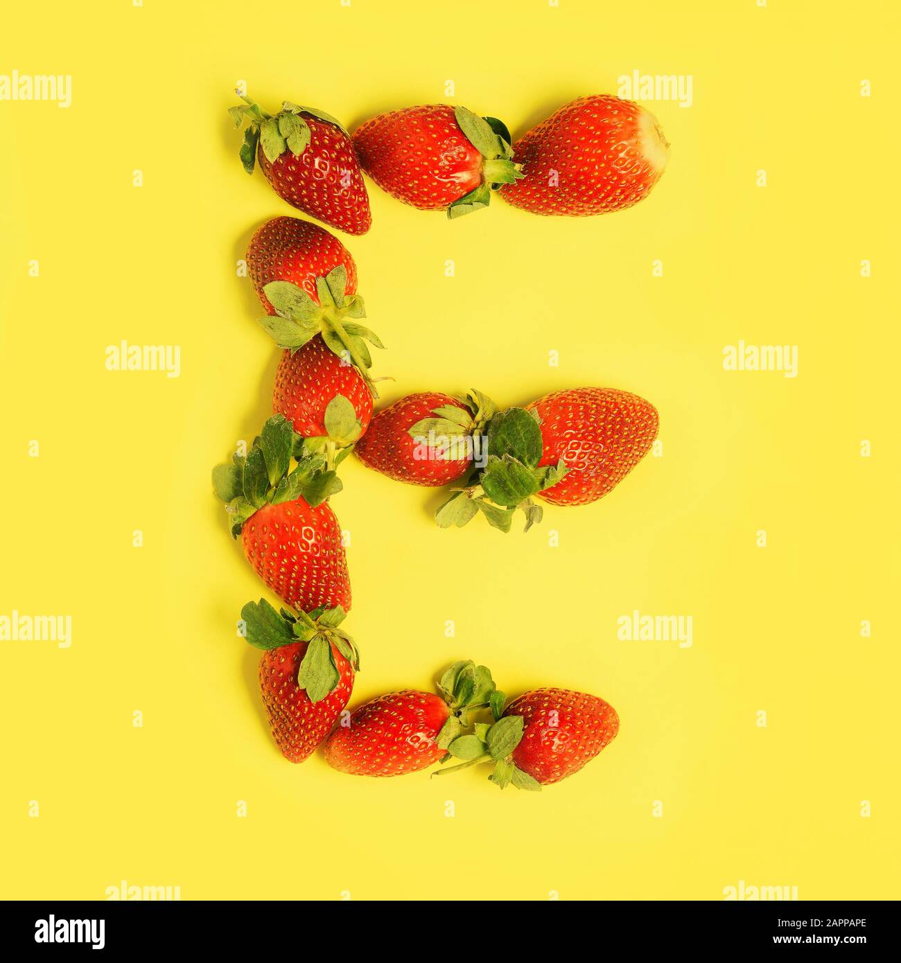 Letter E made from Strawberries on a yellow background. Fruit alphabet ...