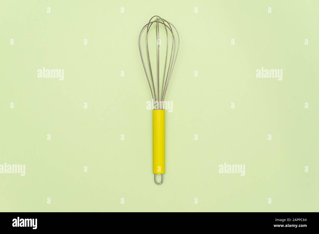 Clean new steel whisk isolated on gren background. Cooking egg beater ...