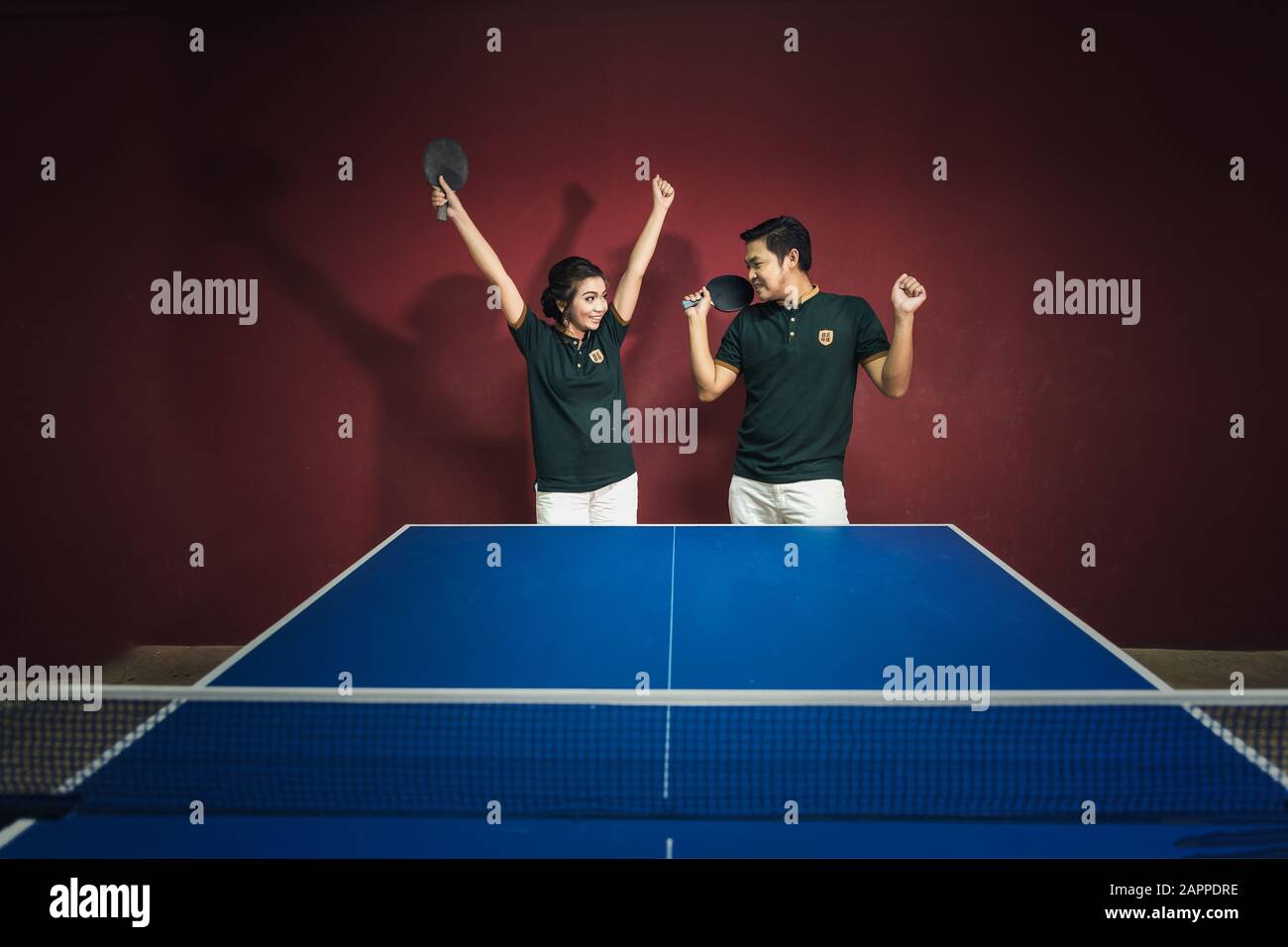 Couples of young people playing ping pong with ping pong paddles having ...