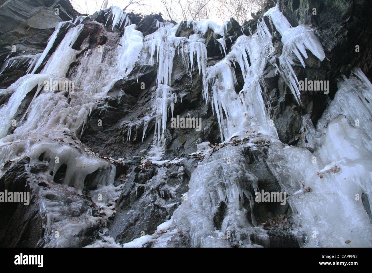 Large icicles covering rocky slope Stock Photo - Alamy