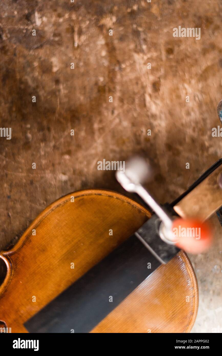 Violin maker at work in the laboratory with tools in Cremona Stock ...