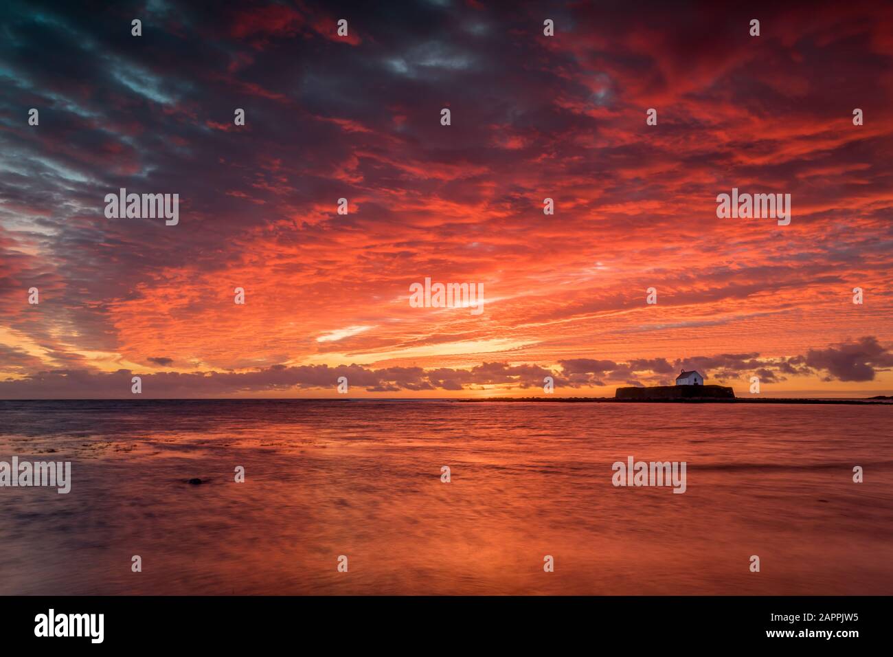A spectacular sunset at St Cwyfan's Church, Anglesey, Wales Stock Photo ...
