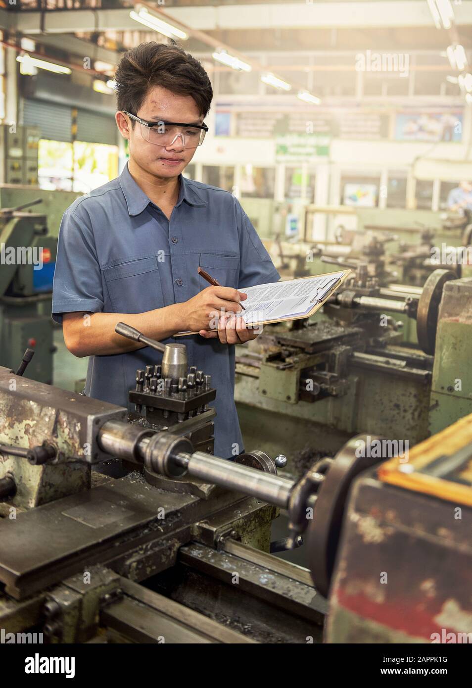 Factory worker writing report Stock Photo - Alamy
