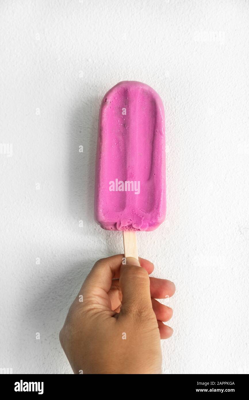 woman hand holding pink stick cold ice scream for summer refreshment on ...