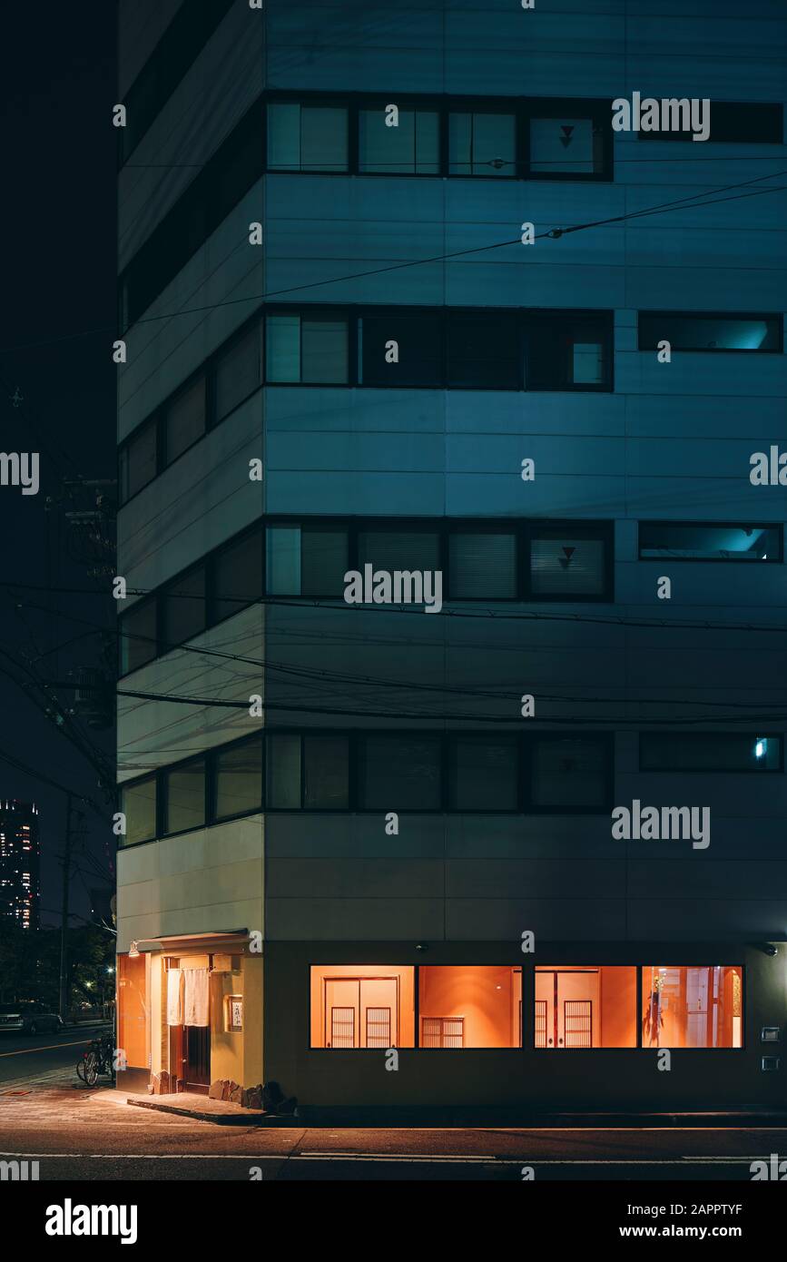 Night scene of an apartment building with the ground floor lit up ...