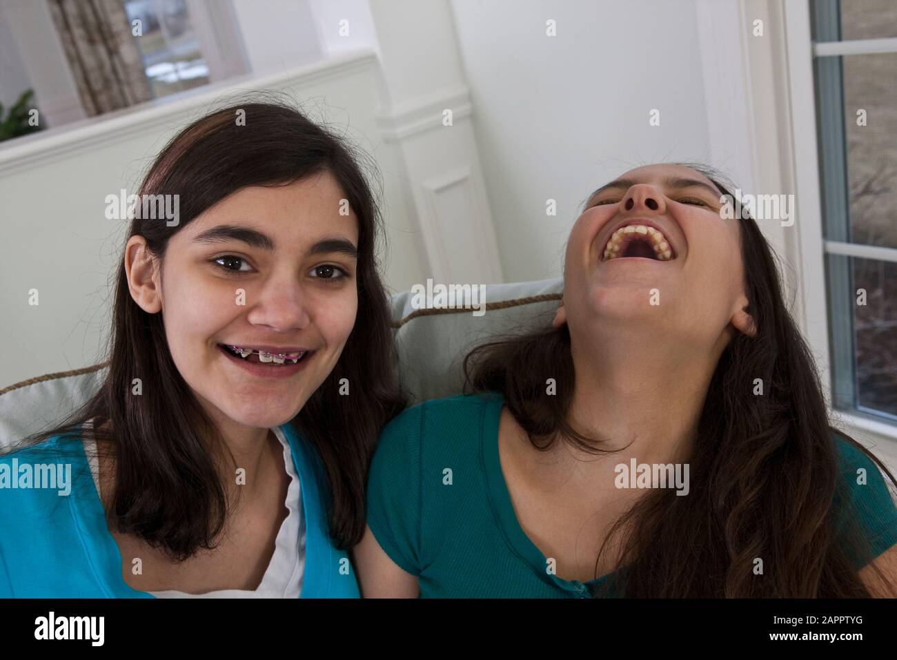 Two teenage girls enjoying time together, one putting her head back in ...
