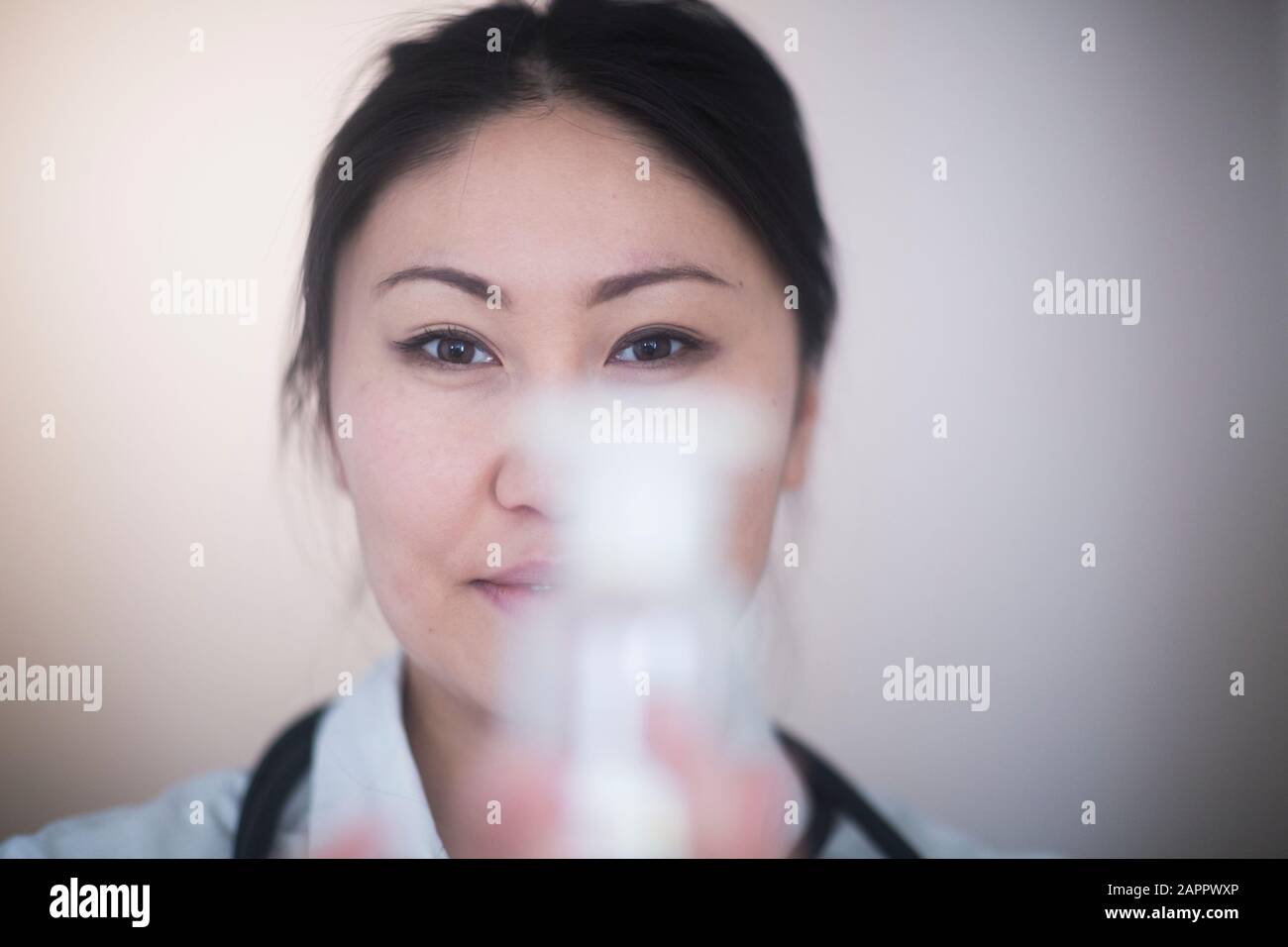 Asian woman looking at blurred image of object Stock Photo - Alamy