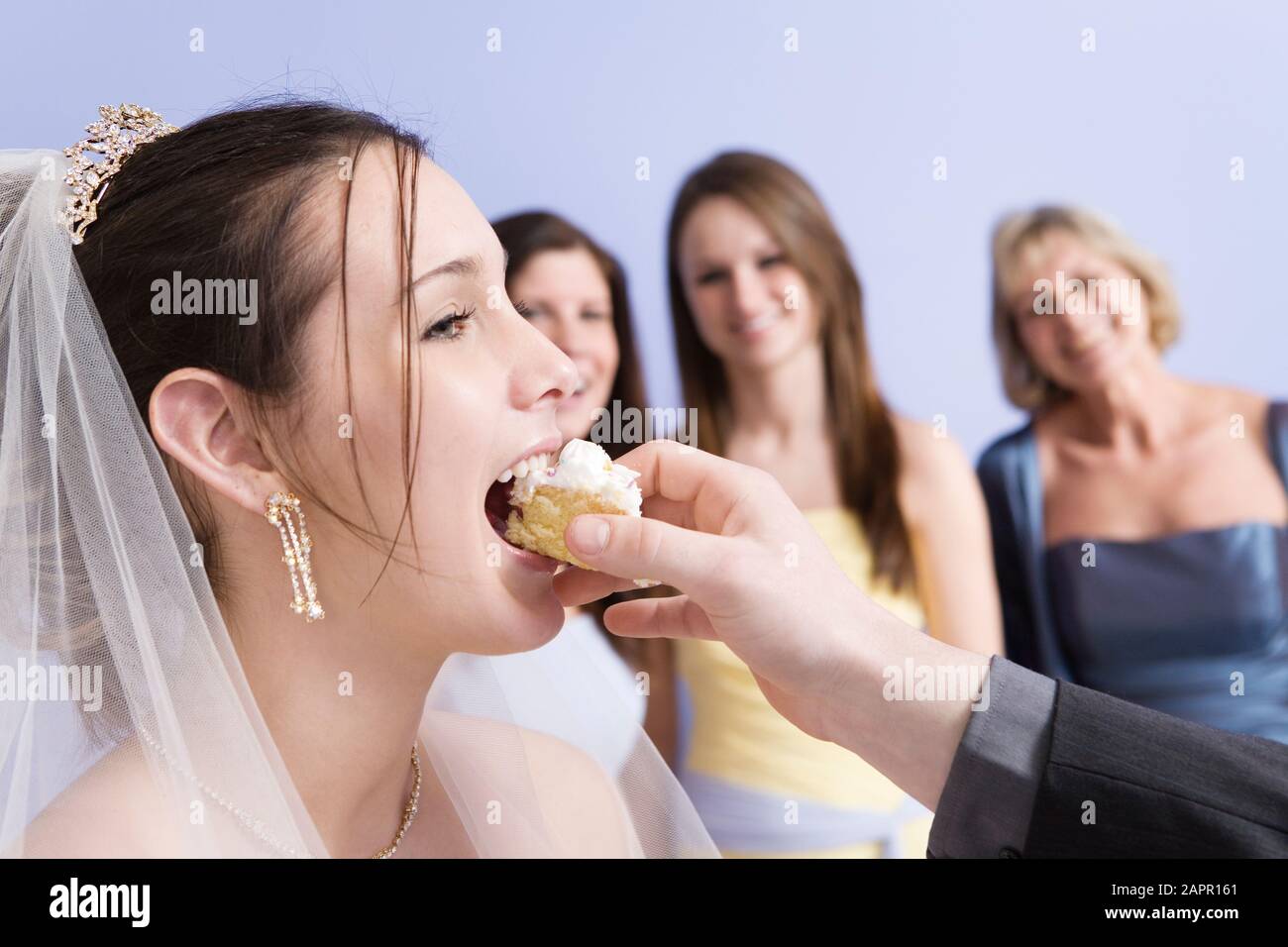 Side view of a bride eating cake Stock Photo - Alamy