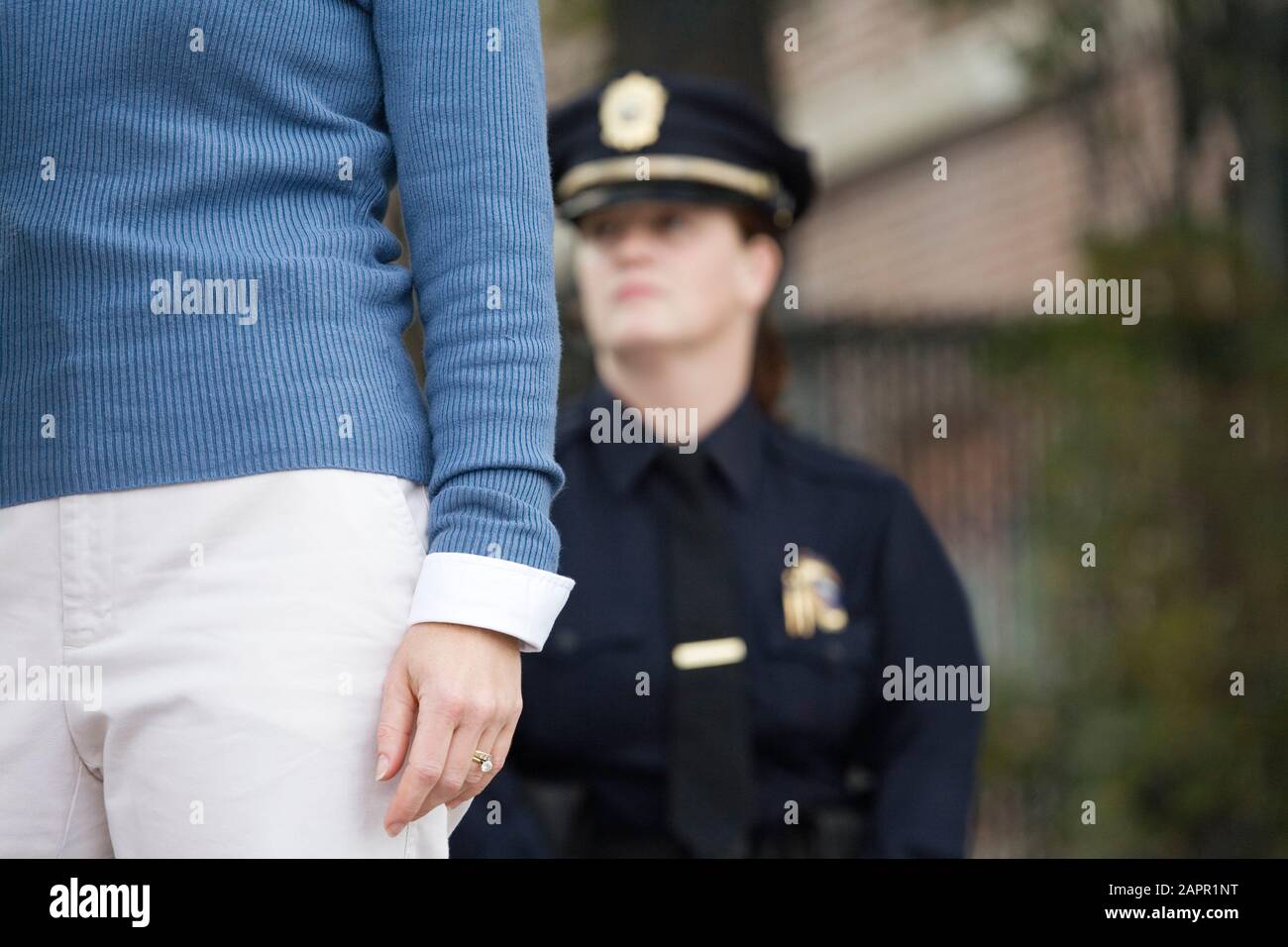 Female police officer watching a woman walking on a street Stock Photo ...
