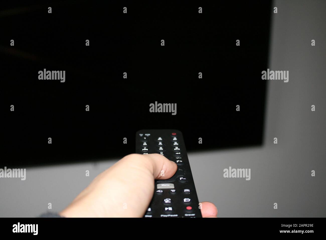 The remote is aimed at the tv in his hand hi-res stock photography and ...