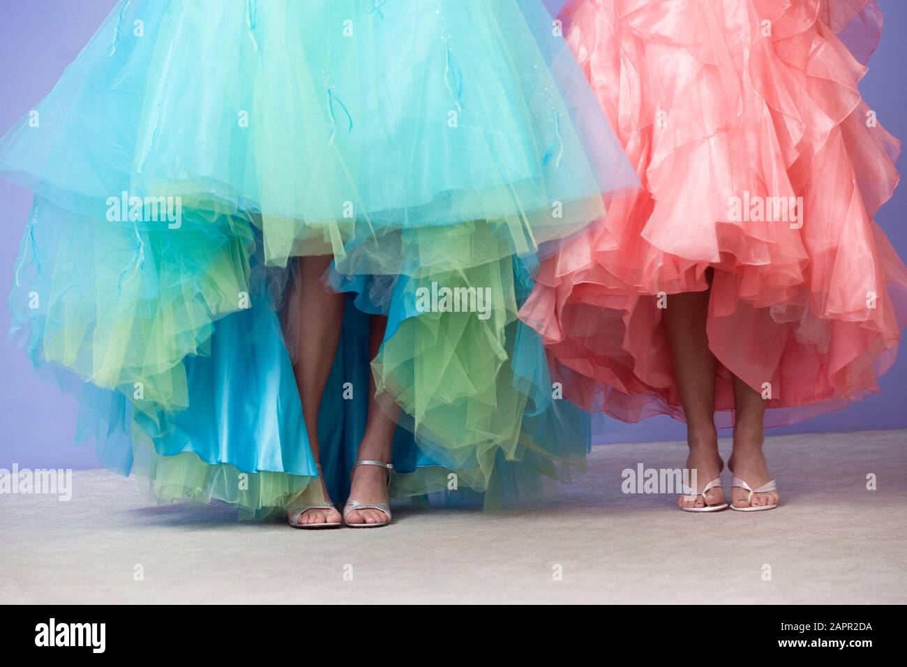 Low section of two friends dancing wearing prom dresses Stock Photo - Alamy