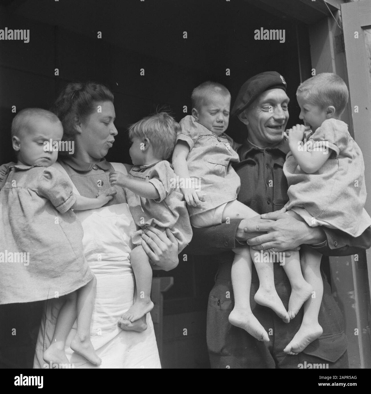Red Cross: Rotterdam [Four toddlers on the arms of a caregiver and a ...