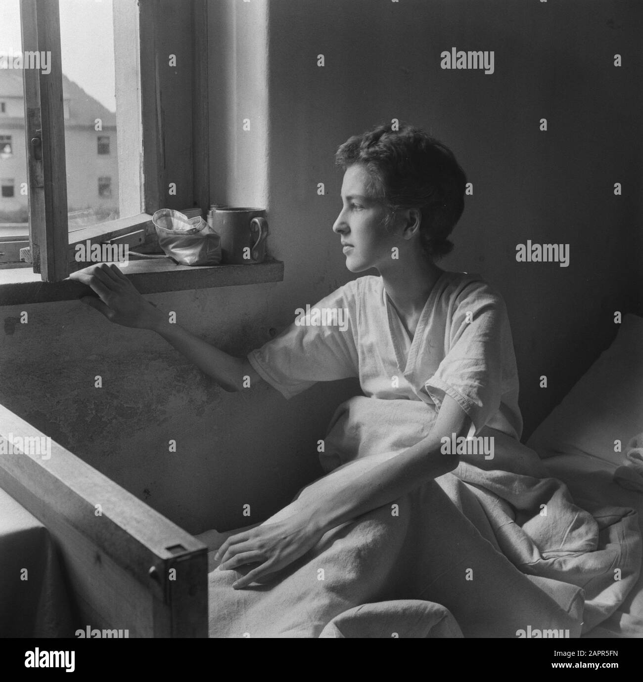Repatriation camp Bergen-Belsen [Emaciated woman looks out from her bed ...