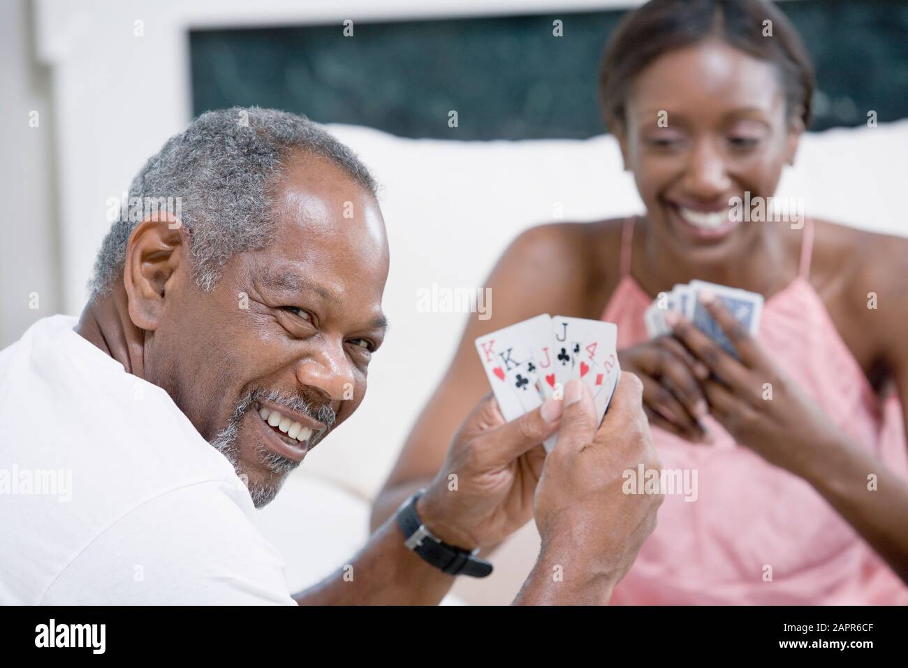 Portrait of a middle-aged man playing cards with a middle-aged woman ...