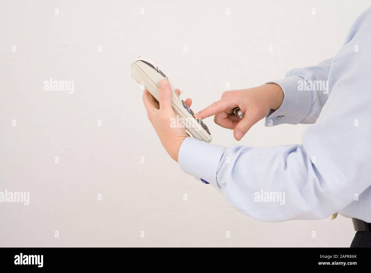 Mid section view of a businessman operating an adding machine tape ...