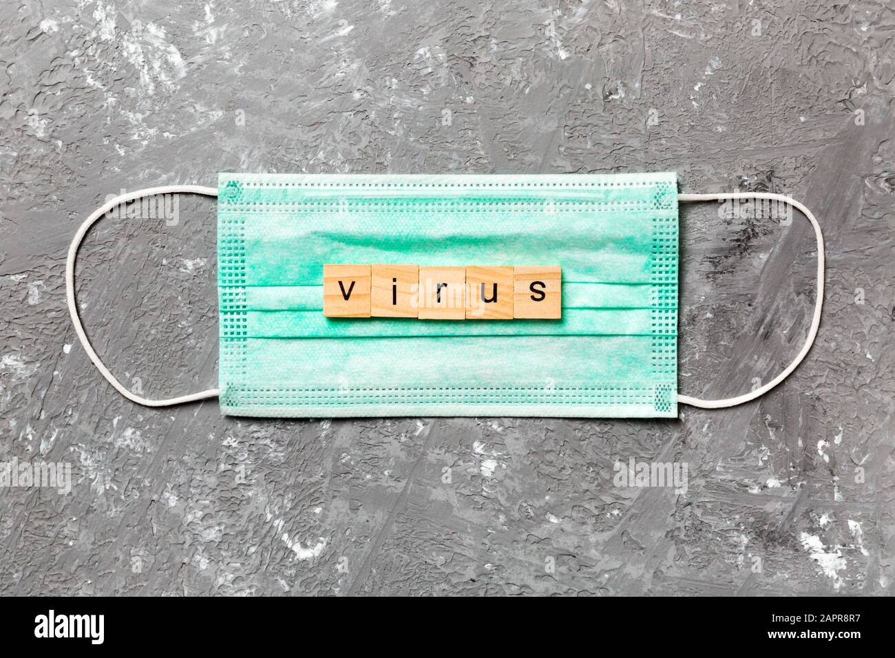 virus word written on wood block lying on medical mask. virus text on ...