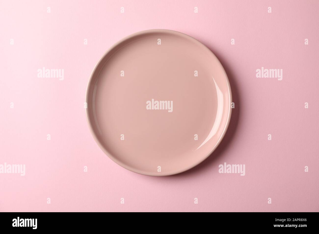 Plate on pink background, top view and space for text Stock Photo - Alamy